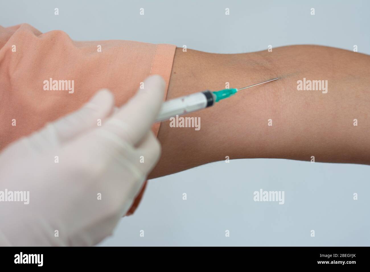 Doctor using a syringe in a patient's arm Stock Photo - Alamy