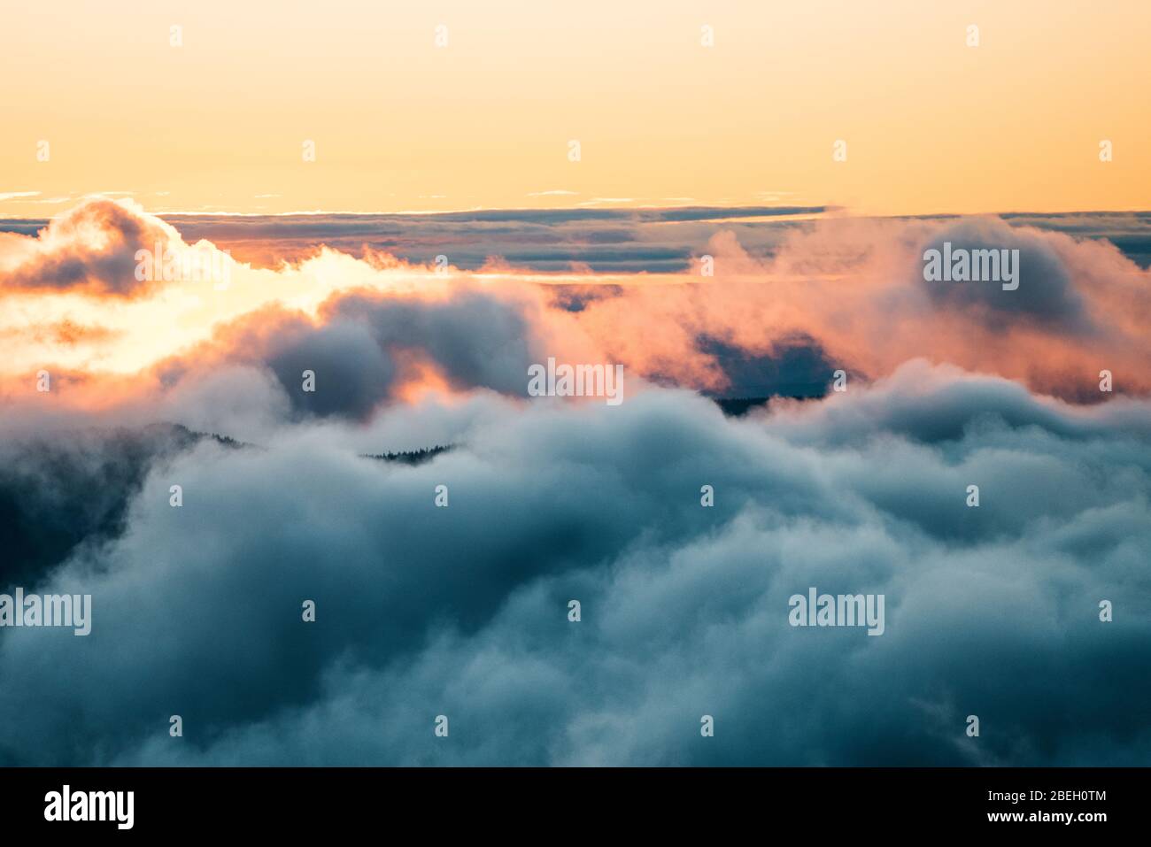 Landscape of sun breaking through clouds and fog at sunrise Stock Photo ...
