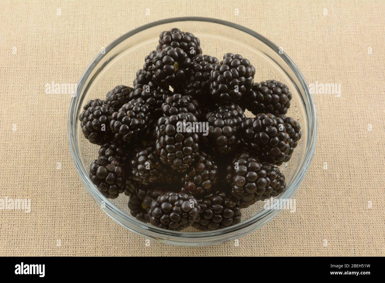 Fresh raw blackberries in glass fruit bowl on tan tablecloth Stock ...