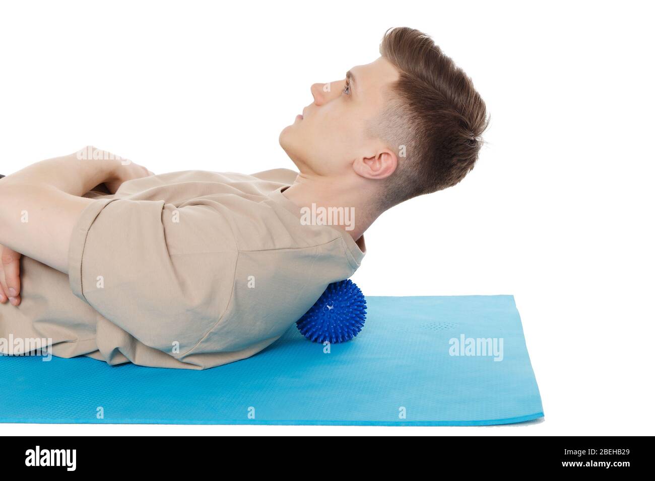 Handsome man shows exercises using the ball with spikes for a ...