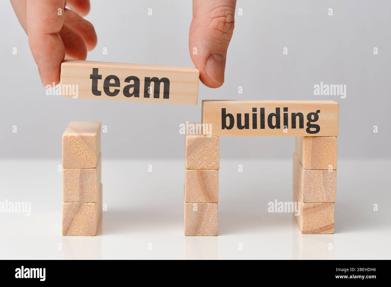 Concept of team building - hand holds a wooden block with the ...