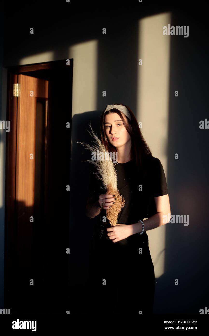 A young beautiful girl is in an apartment during self-isolation. She is ...
