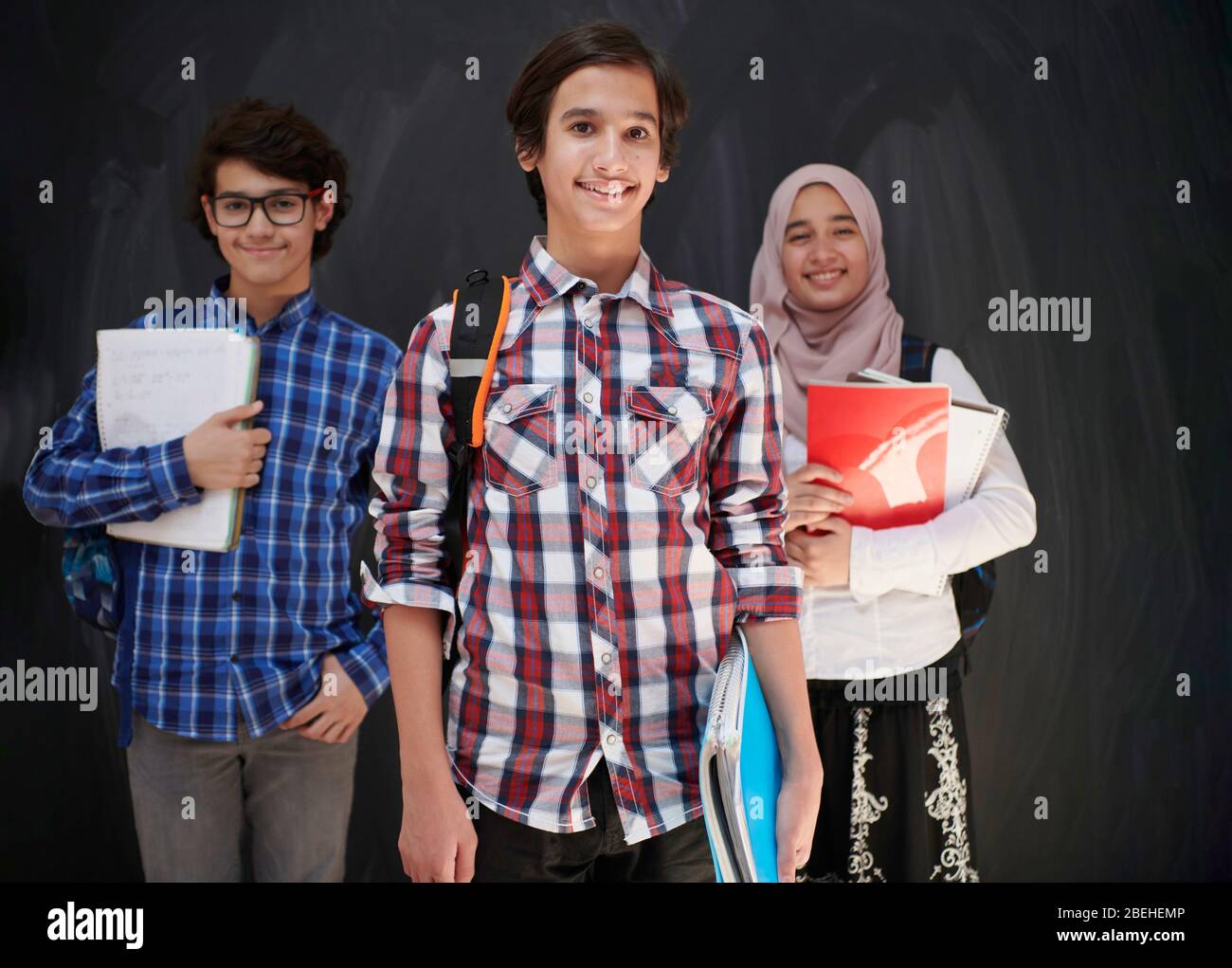 Arabic teenagers, students group portrait against black chalkboard ...