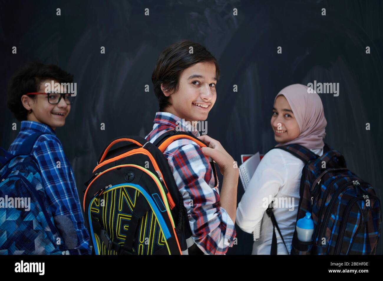 Arabic teenagers, students group portrait against black chalkboard ...
