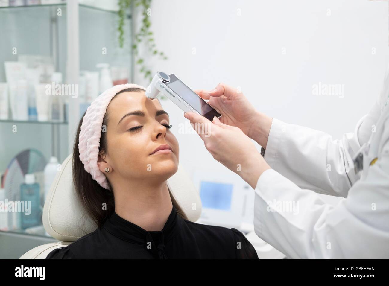A beautiful girl doing facial care analyzing the skin of the face with ...