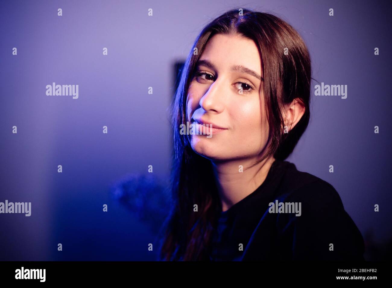 A young beautiful girl is quarantined in an apartment. Low key and blue ...