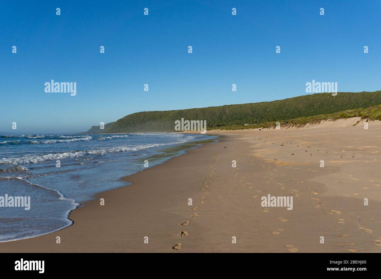 Empty sand beach landscape with waves and sand with footprints. Summer ...