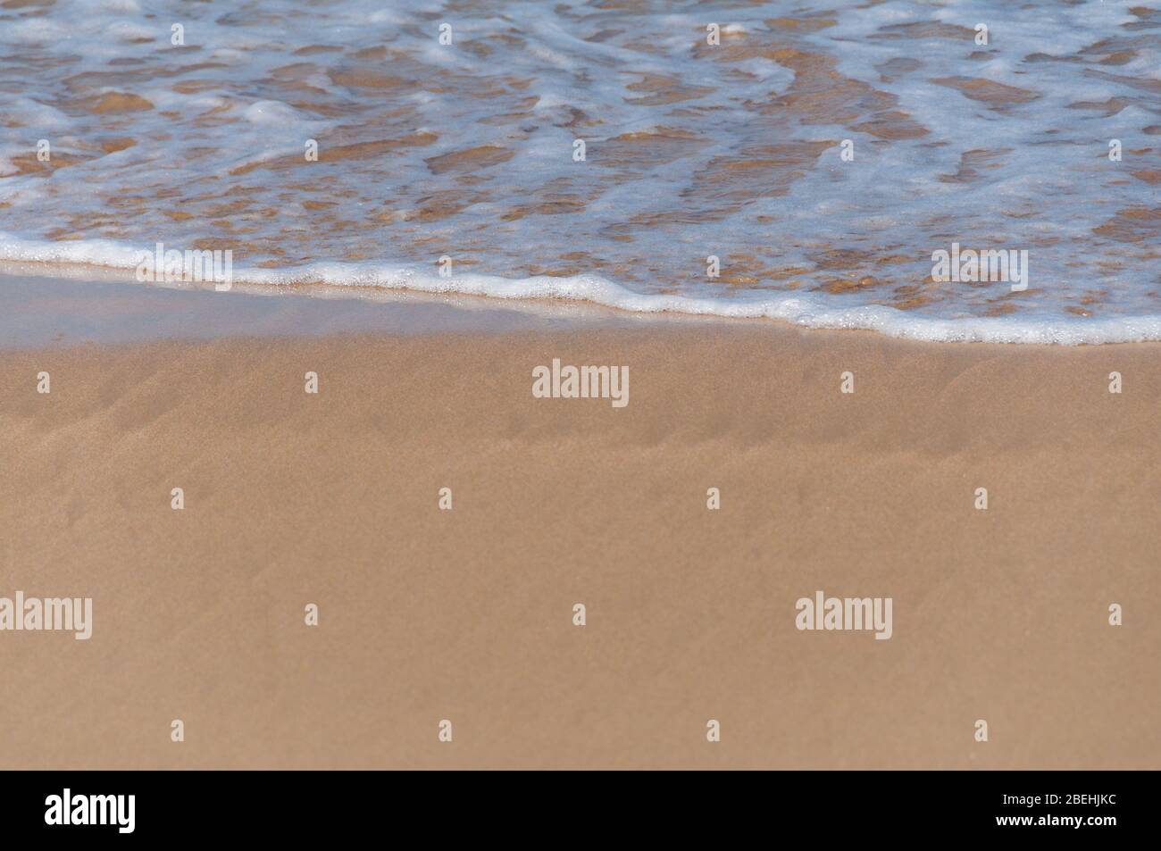 Close up of water edge, wave with white foam on sandy beach. Summer ...