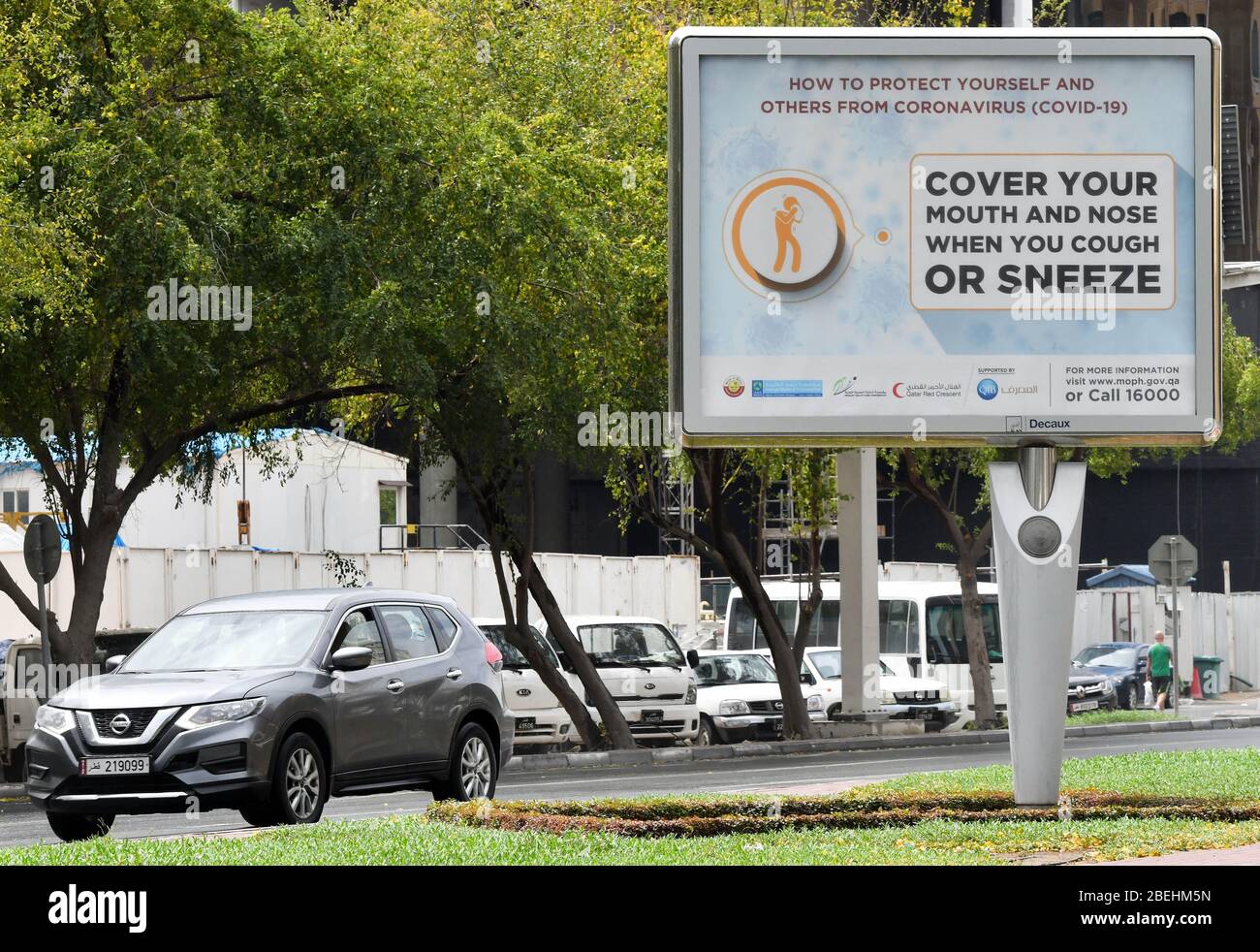 Doha, Qatar. 13th Apr, 2020. A car passes by a COVID-19 awareness ...