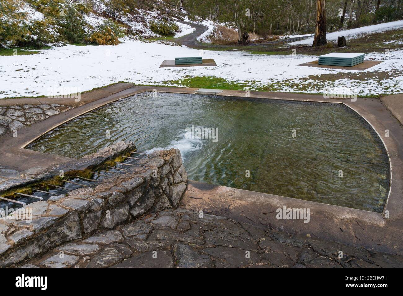 Outdoor swimming pool with winter landscape and snow. Yarrangobilly hot ...