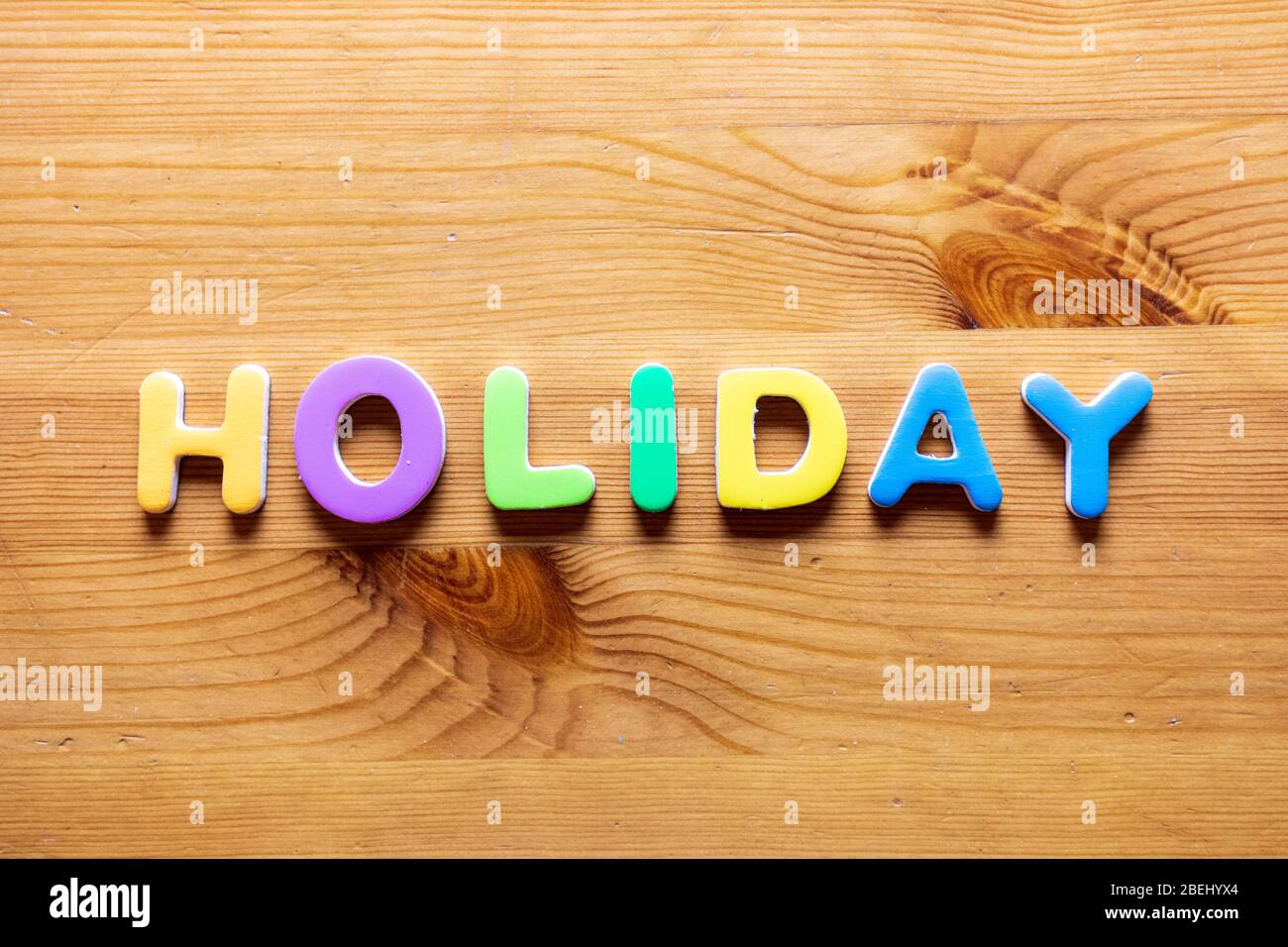 holiday word written with colorful letters on wooden table background ...