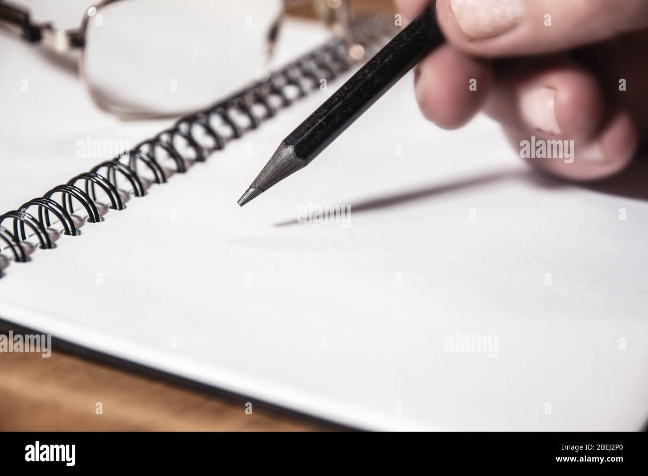 Closeup of a man's hand writing to do list on a notepad. business ...