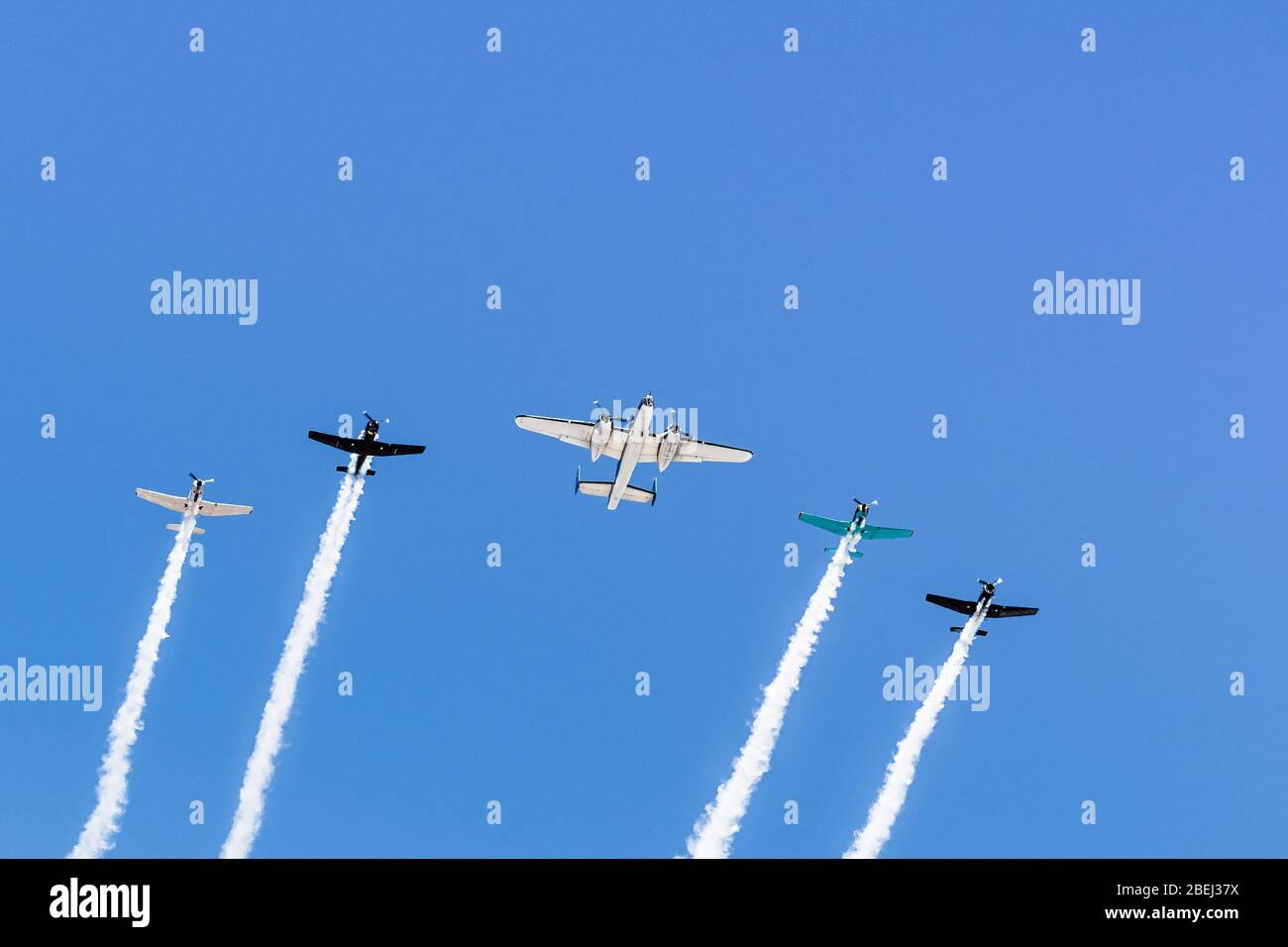 Historical airplanes flying in formation, leaving behind a white smoke ...