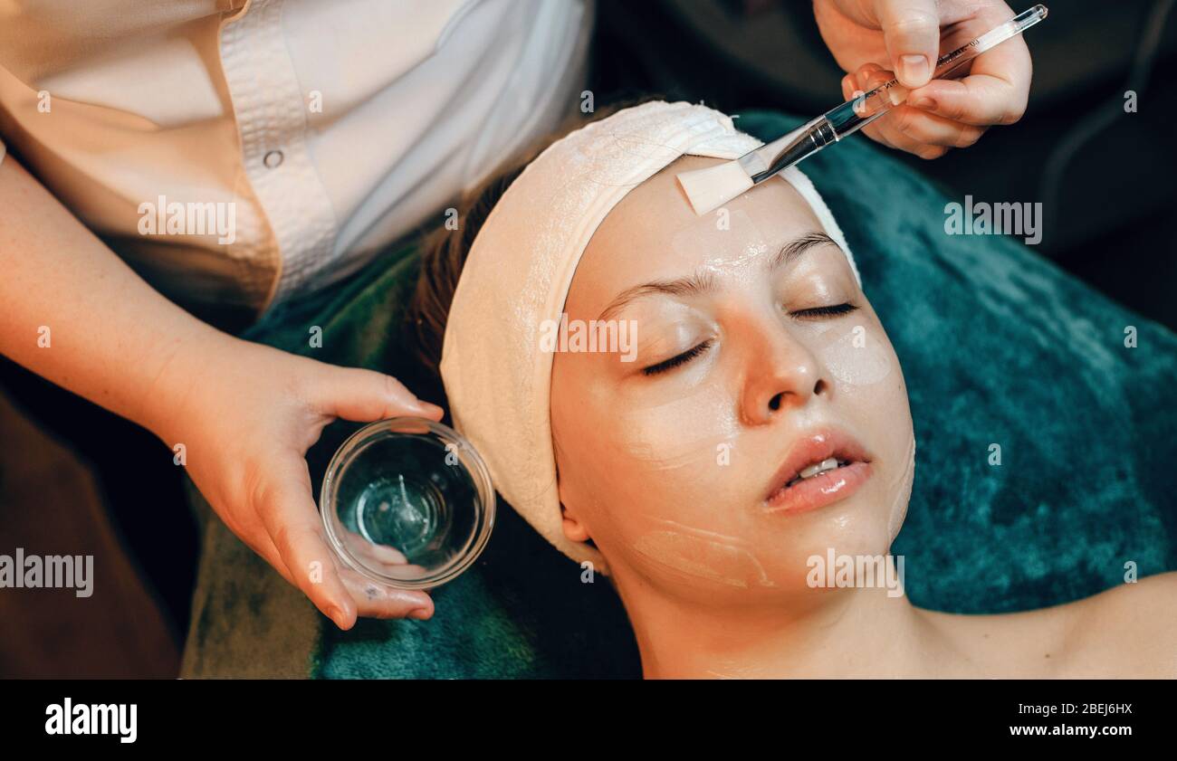 Anti aging facial mask applied to a caucasian woman in a wellness spa ...