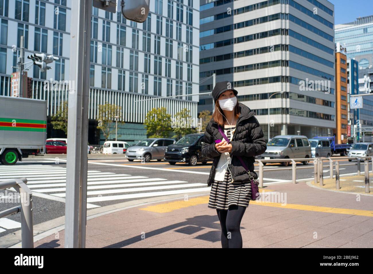Asian female wearing a surgical mask on a street of a major Japanese ...