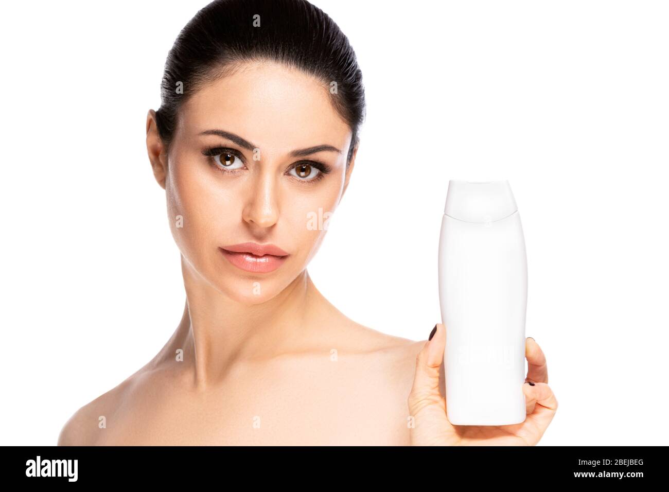 Beautiful woman holding white empty shampoo tube on white background ...