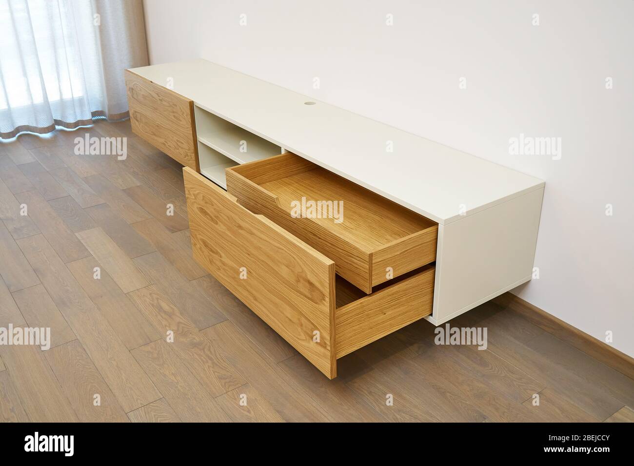 Contemporary floating media cabinet in living room. Wooden wall mounted ...