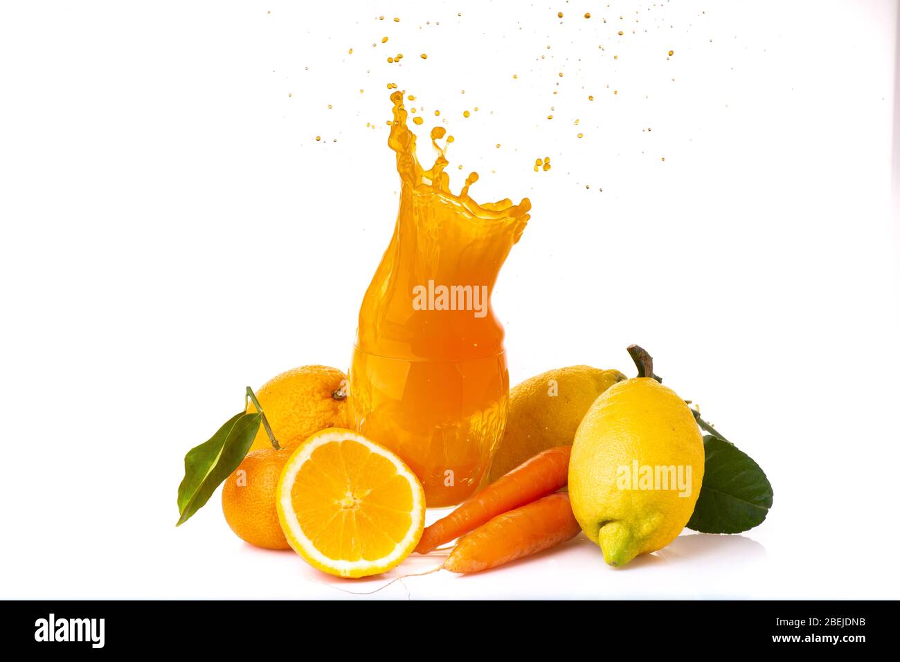 fresh citrus and carrot juice in the glass with splash. White ...