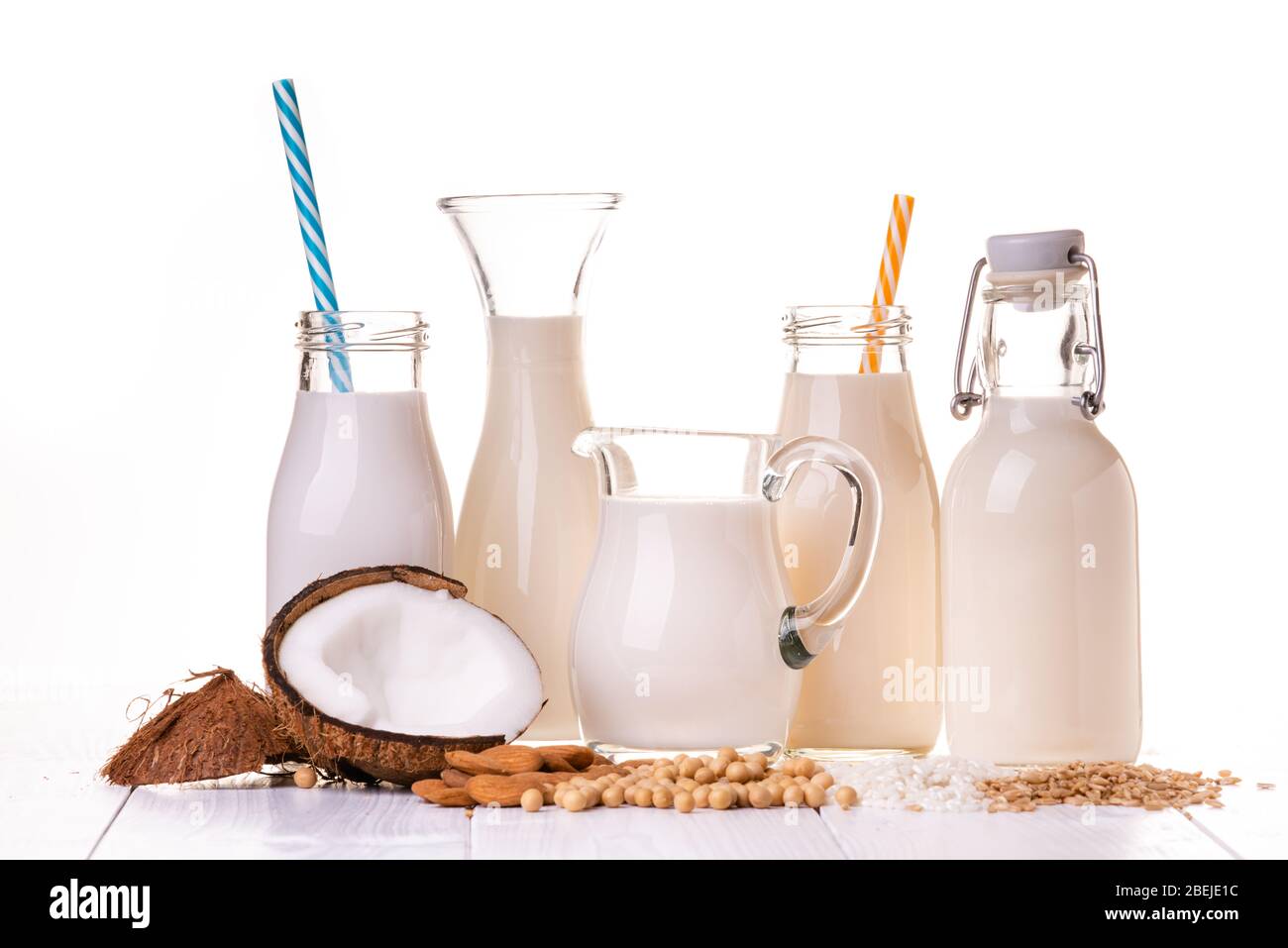 types of vegetable milk, and organic, in glass containers on the table ...