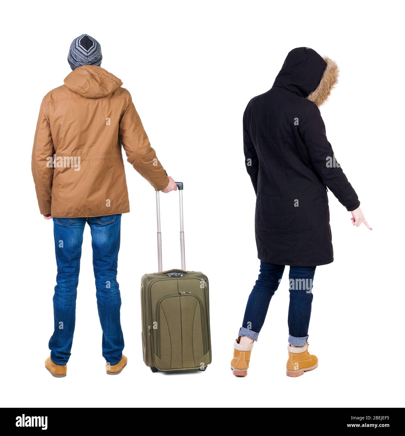 young couple in winter jacket traveling with suitcas. Back view. Rear ...