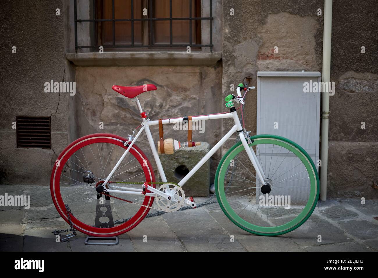 Colored bicycle - red and green, in front of the facade of an old house ...