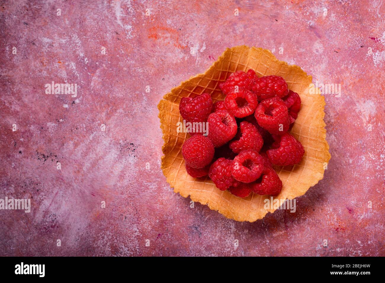 top view of some fresh raspberries in the ice cream wafer on the rustic ...