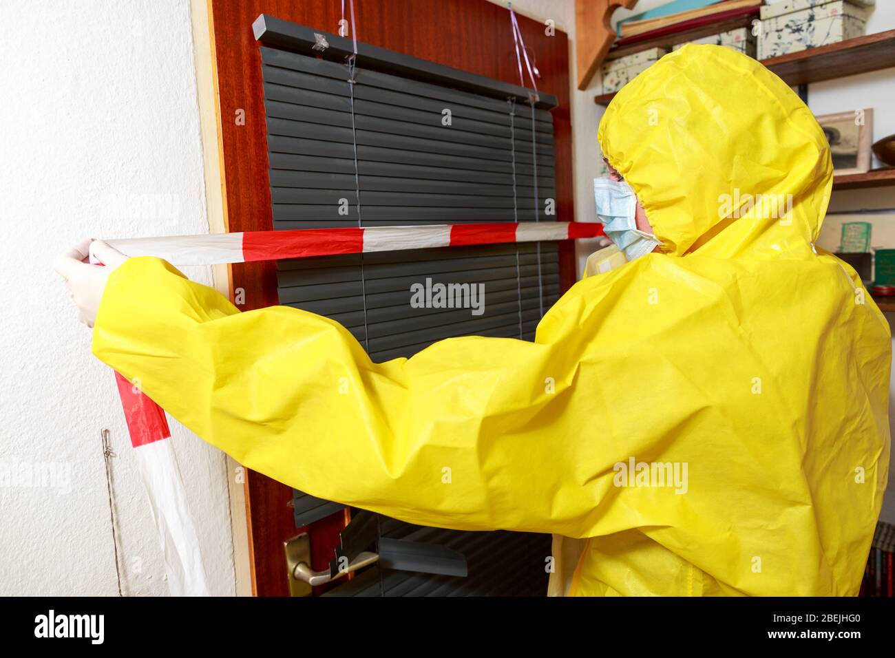 Woman in a full protective suit secures with a barrier tape Stock Photo ...