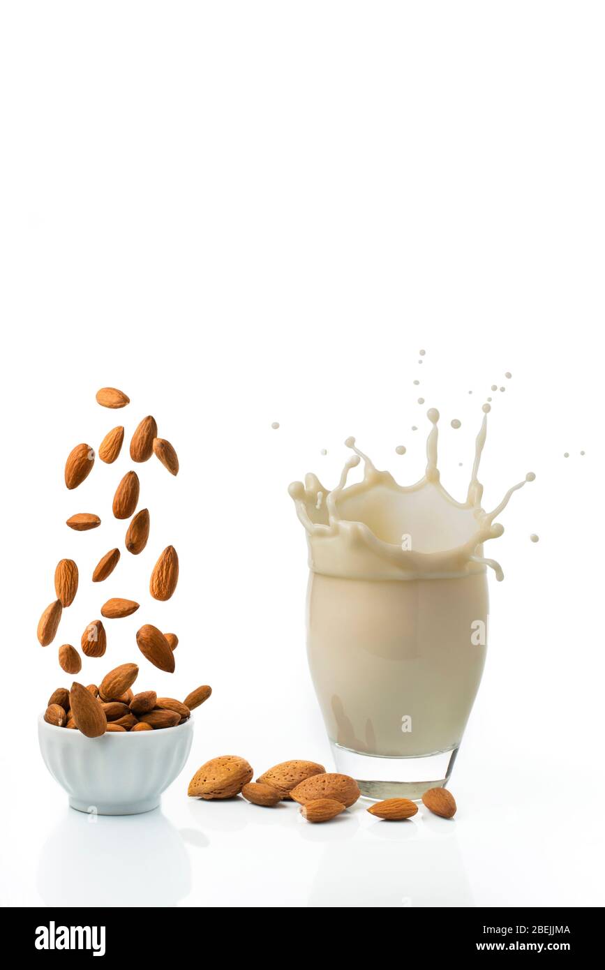glass with almond milk and a splash. separate bowl with shelled almonds ...