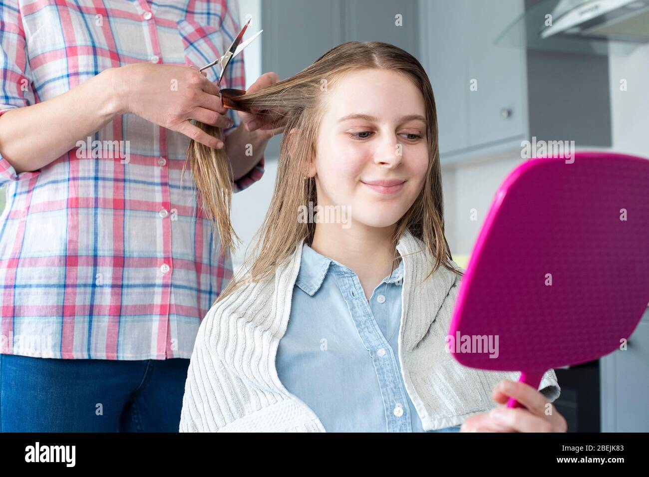 Mother Cutting Teenage Daughters Hair At Home During Lockdown Stock