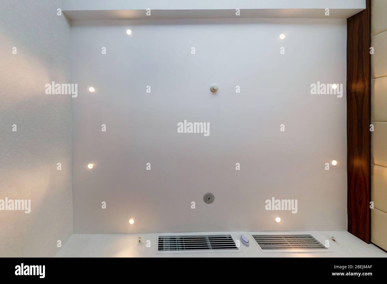 look up on suspended ceiling with halogen spots lamps and drywall ...