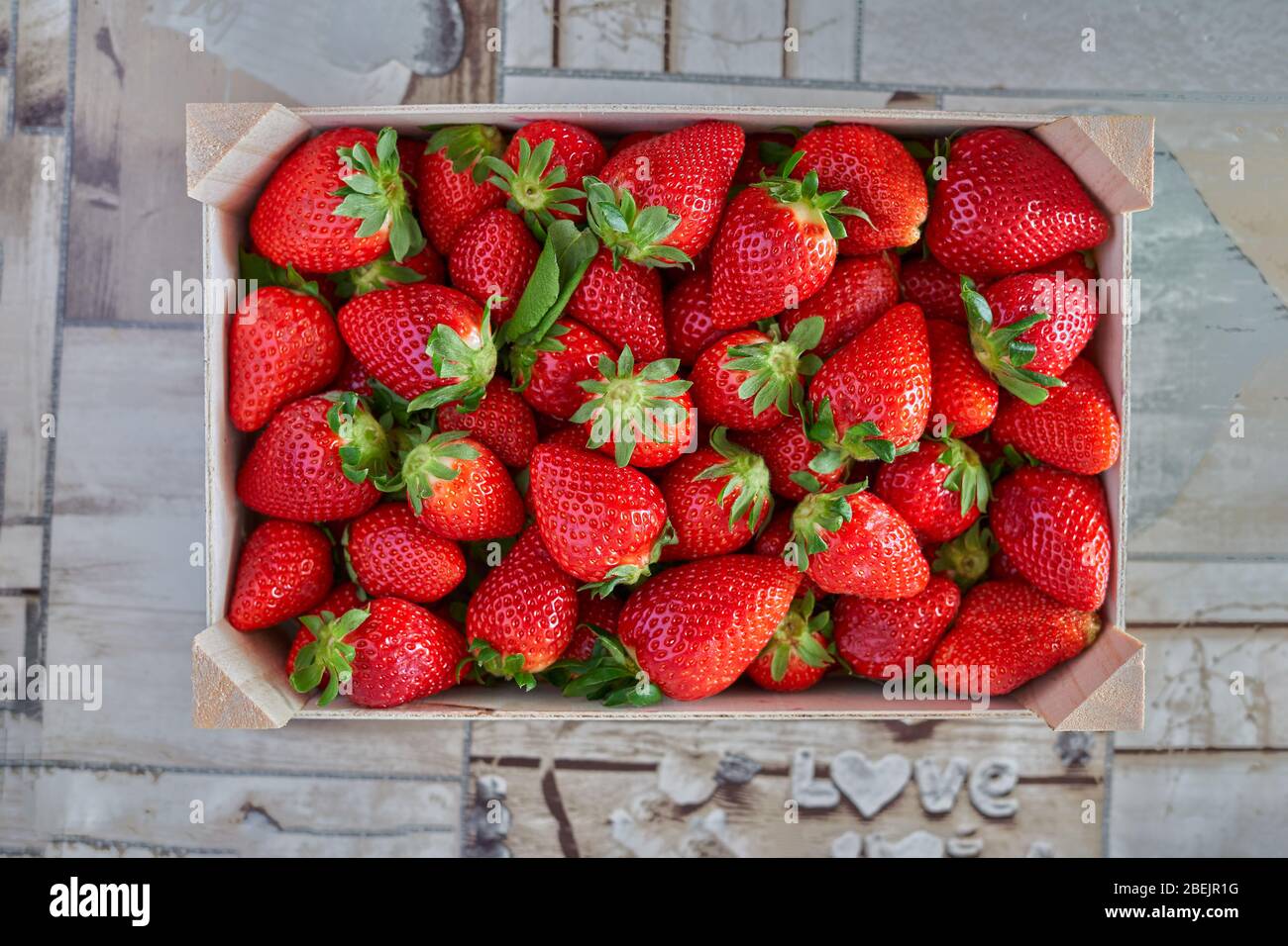 Strawberries of intense red color collected in a farmer's wooden box ...