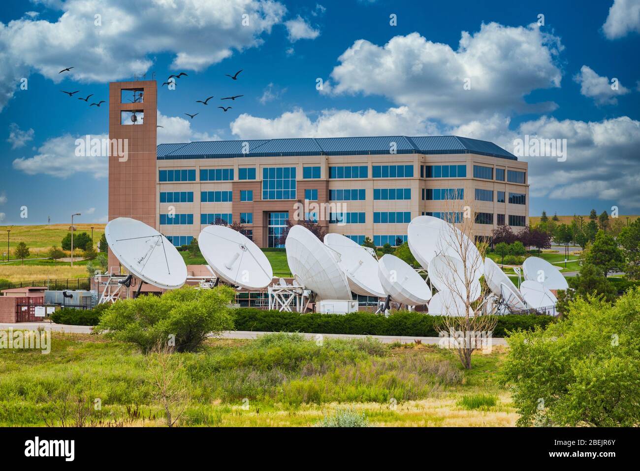 An array of satellite dishes outside a brick and glass building Stock ...
