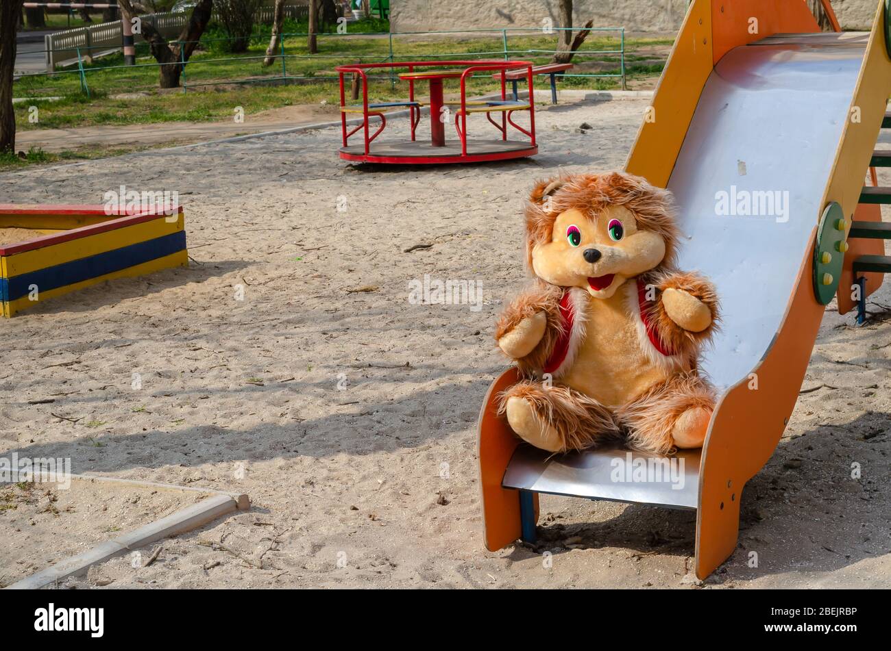Big teddy bear in a deserted playground. A smiling bear sits on a ...