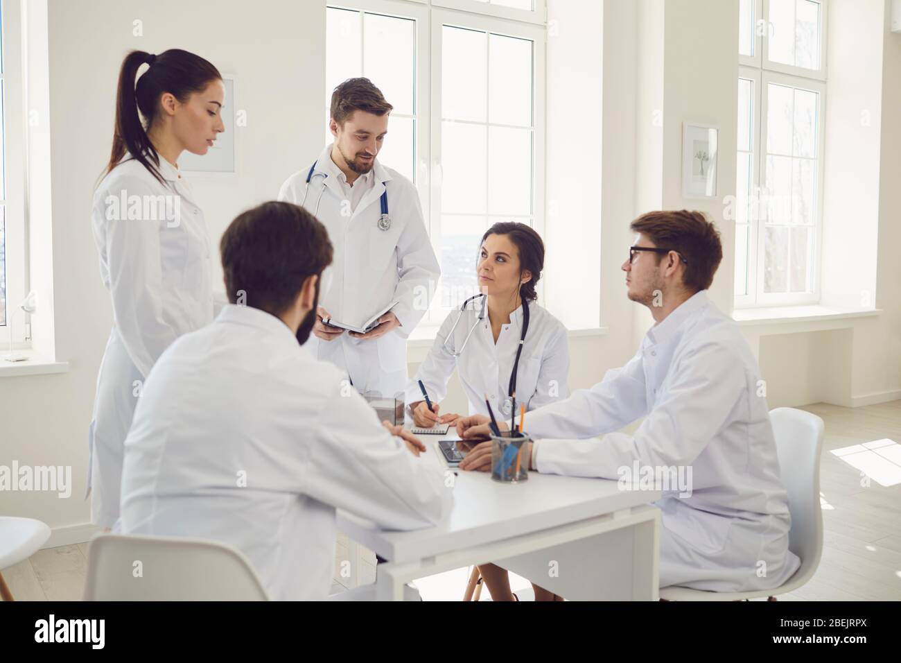 Group of doctors talking sitting at a table in the office of the ...