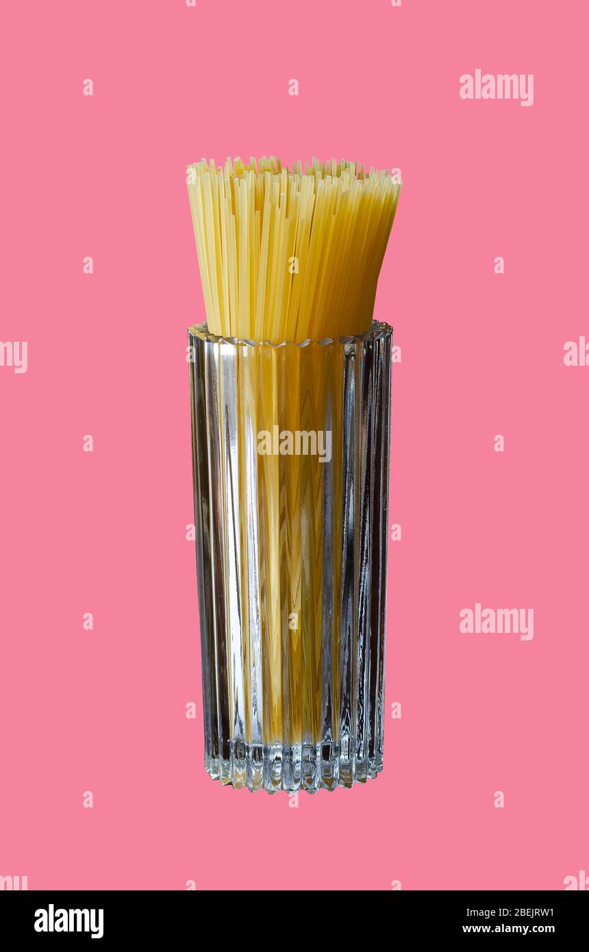 Spaghetti in a tall glass glass. Unprepared pasta. Ingredients for a ...