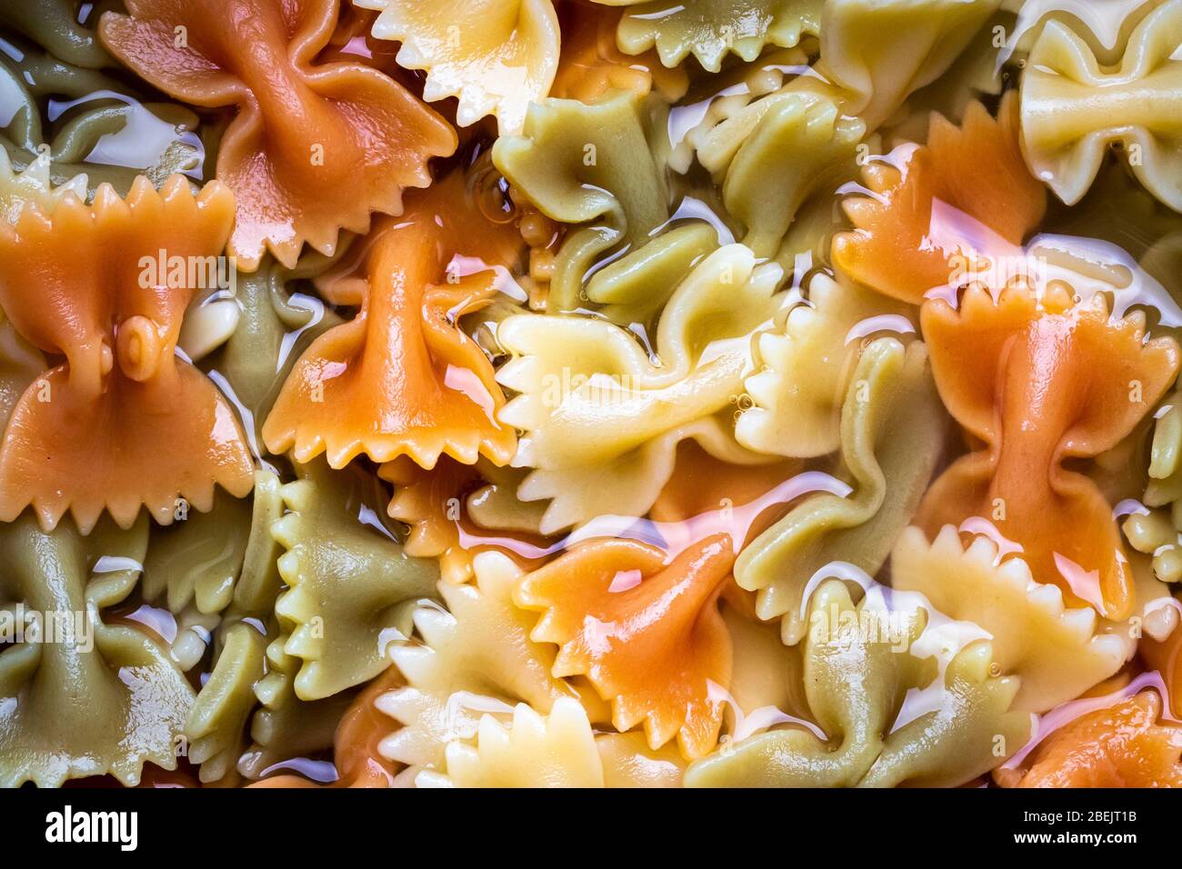 Colored italian cooked pasta farfalle tricolore abstract background ...