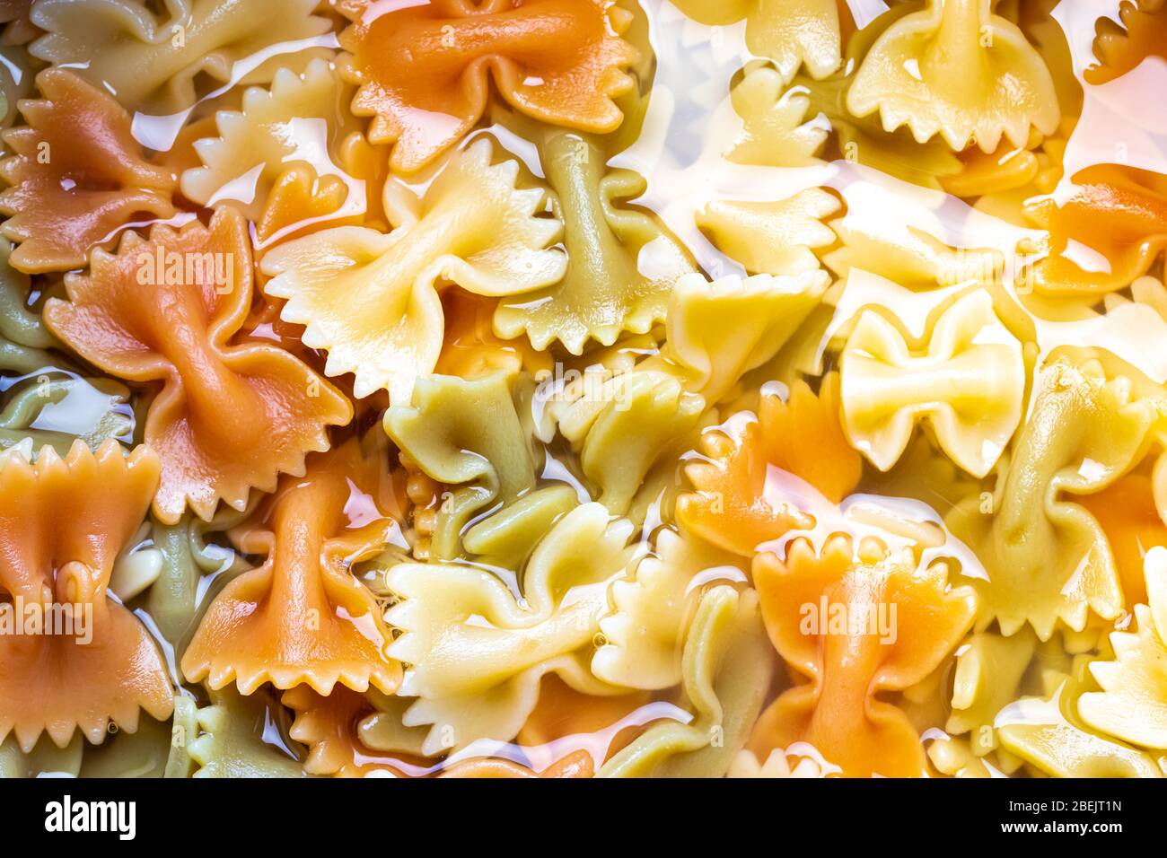 Colored italian cooked pasta farfalle tricolore abstract backdrop ...
