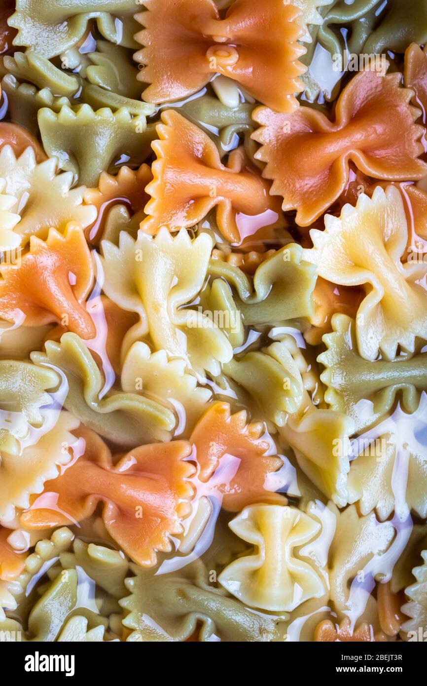 Colored italian cooked pasta farfalle tricolore abstract backdrop ...