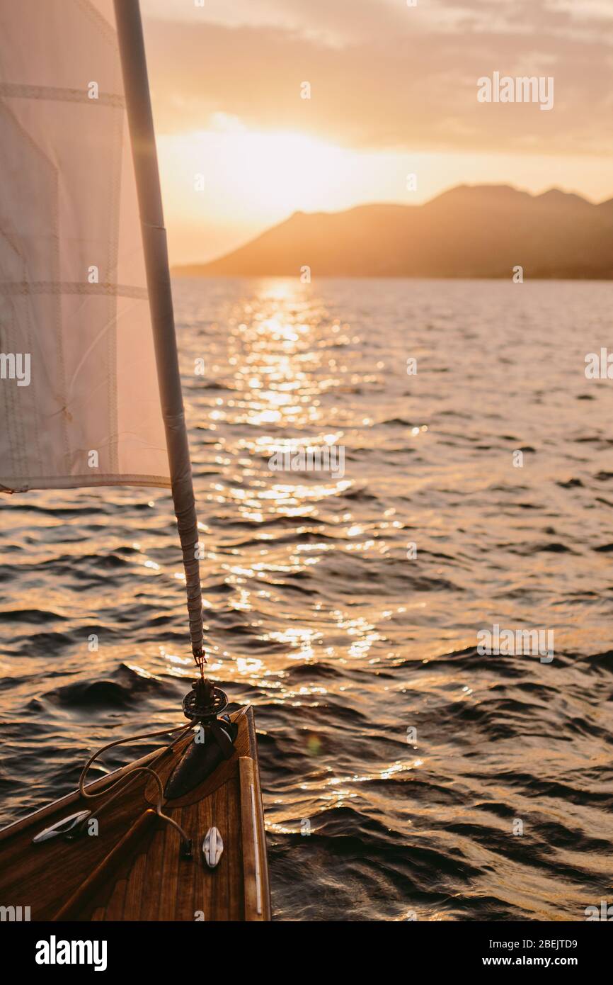 yacht sailing at sunset in sea with mountains view. Romantic sailing ...