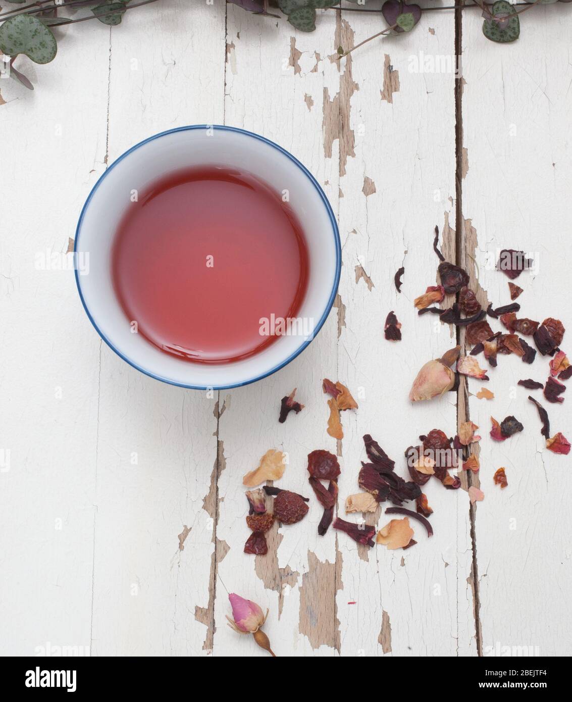 A high view of a cup of Rosehip Tisane with loose leaves on the side ...