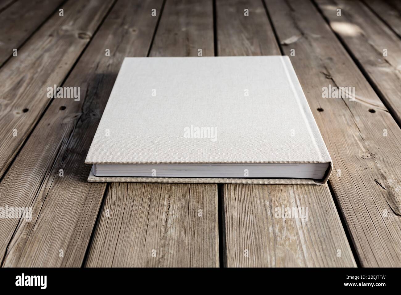 Wedding albums on beautiful wood background. Cloth cover without names ...