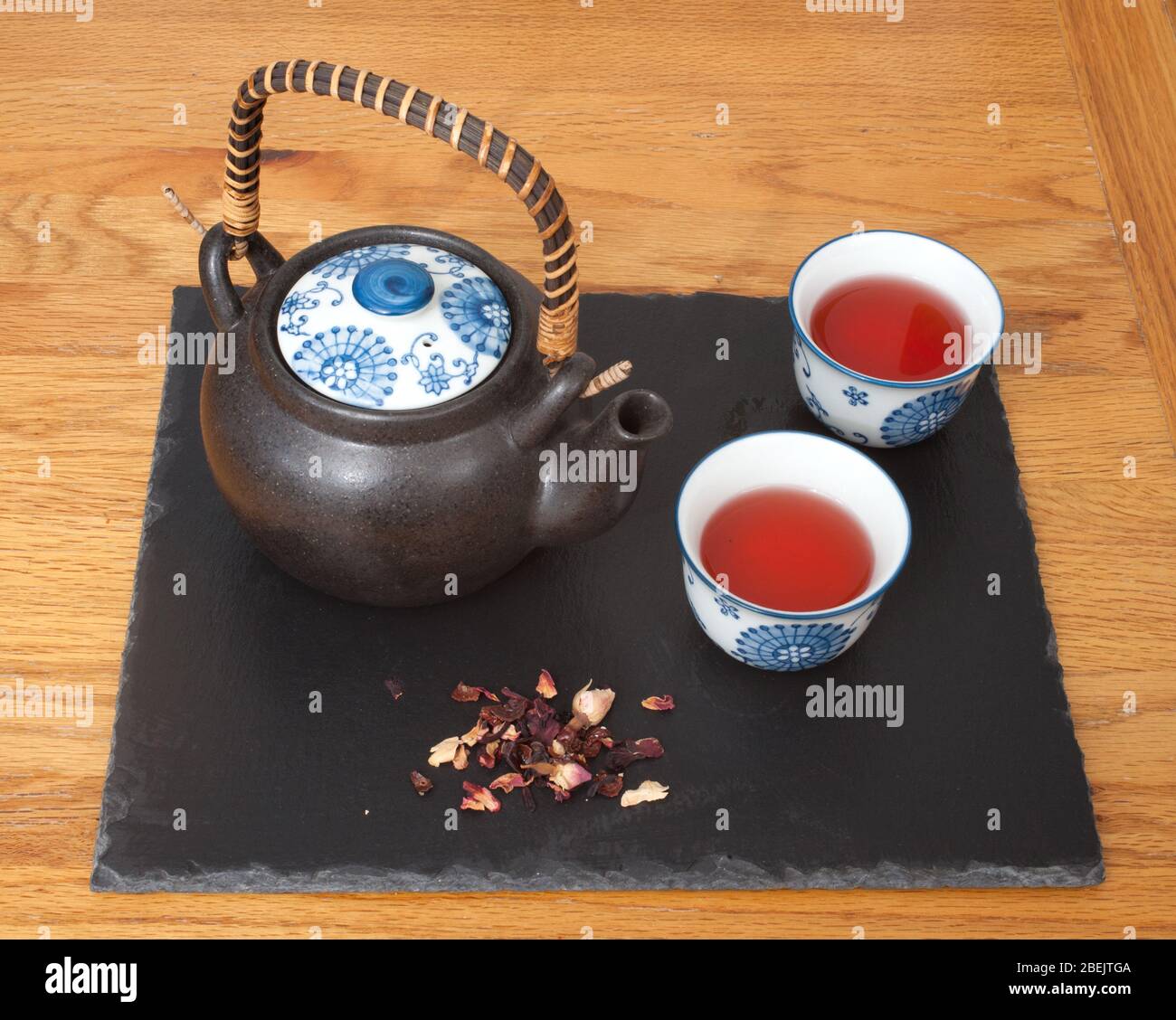 Two cups of Rosehip Tisane with an oriental teapot and loose leaves ...