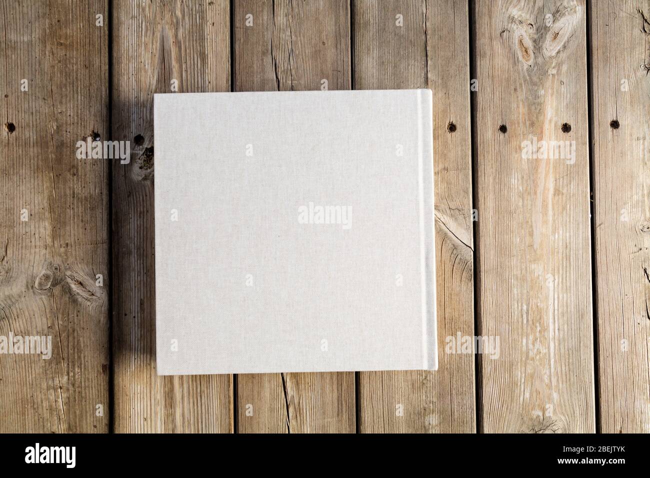 Wedding albums on beautiful wood background. Cloth cover without names ...