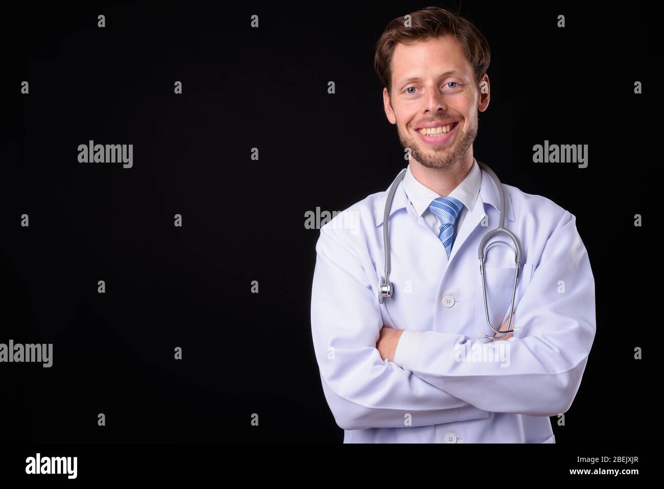 Portrait of happy bearded man doctor smiling with arms crossed Stock ...