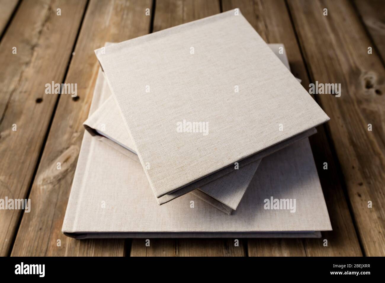 Wedding albums on beautiful wood background. Cloth cover without names ...