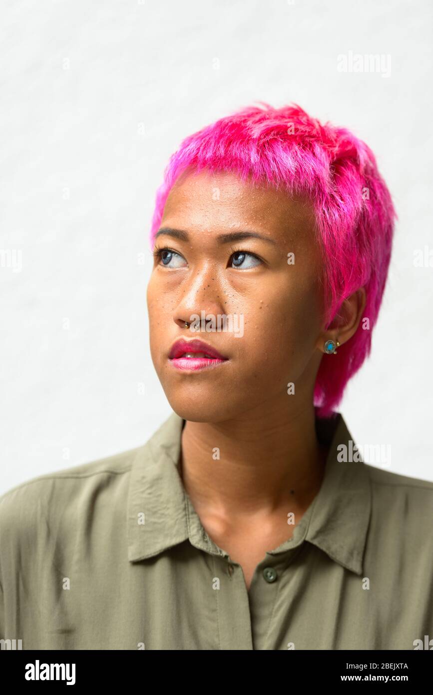 Face of young rebellious Asian woman with pink hair thinking Stock ...