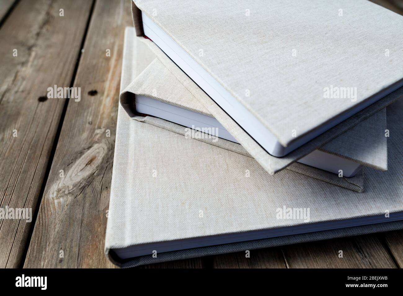 Wedding albums on beautiful wood background. Cloth cover without names ...