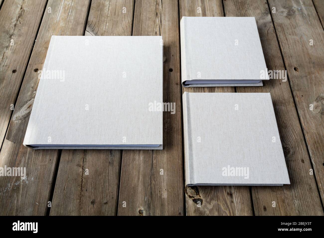 Wedding albums on beautiful wood background. Cloth cover without names ...