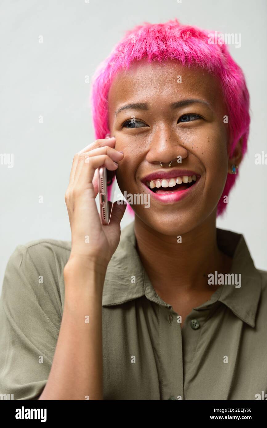 Face of happy young rebellious Asian woman talking on the phone Stock ...