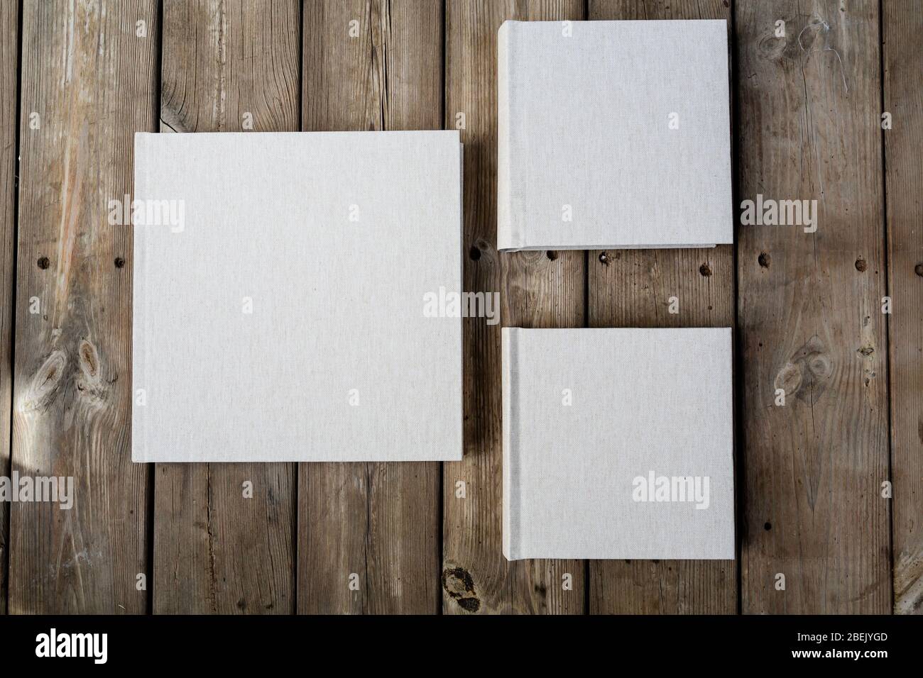 Wedding albums on beautiful wood background. Cloth cover without names ...